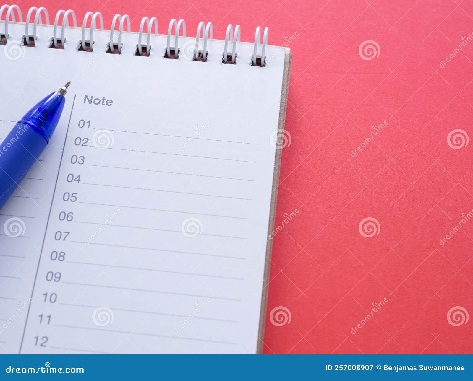 Notepad with Numbers 01-12 and Blue Pen on a Red Workplace Offiec ...