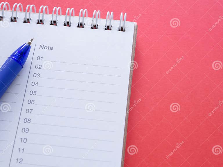 Notepad with Numbers 01-12 and Blue Pen on a Red Workplace Offiec ...