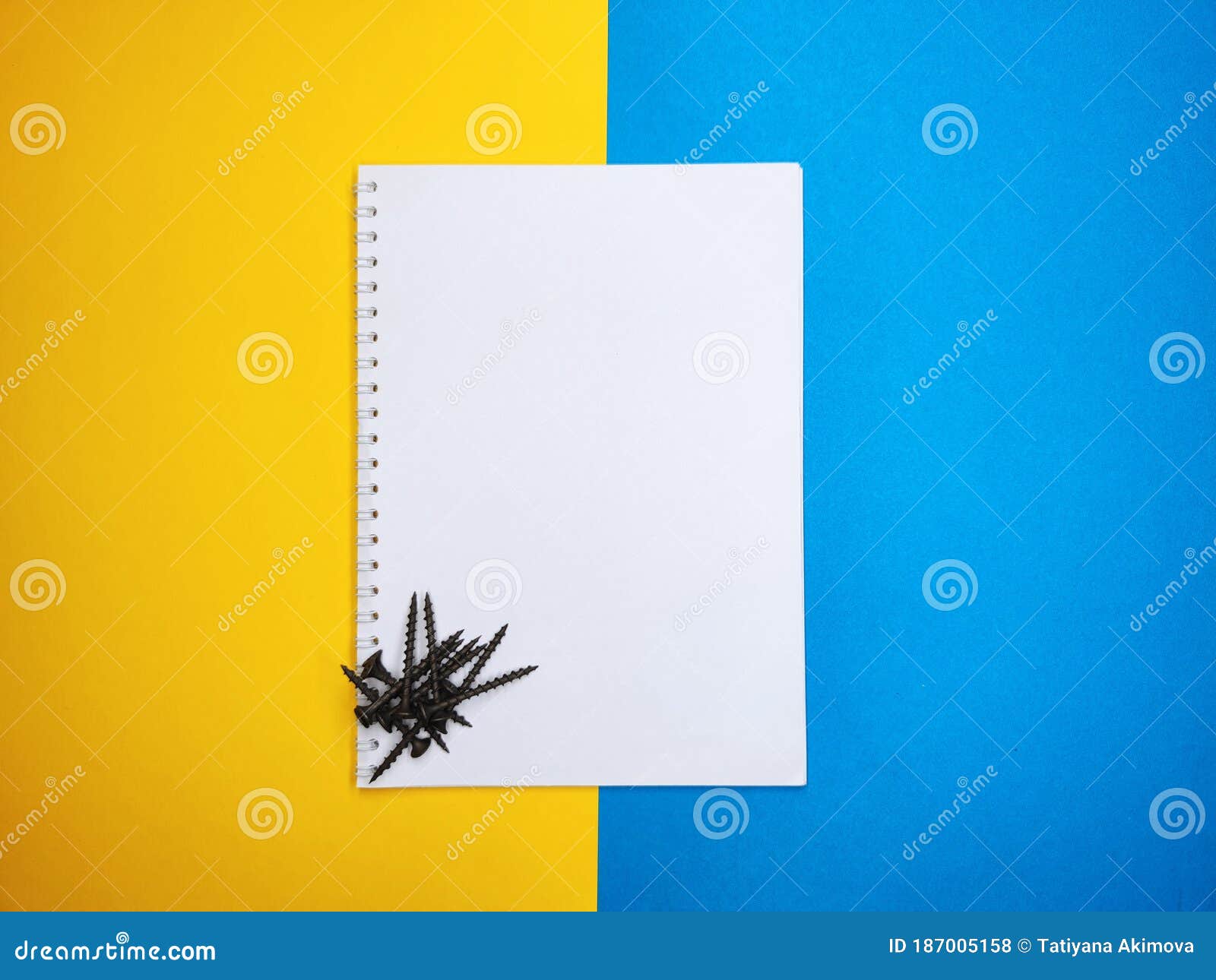 Notepad with Screws in the Lower Left Corner on a Yellow and Blue ...