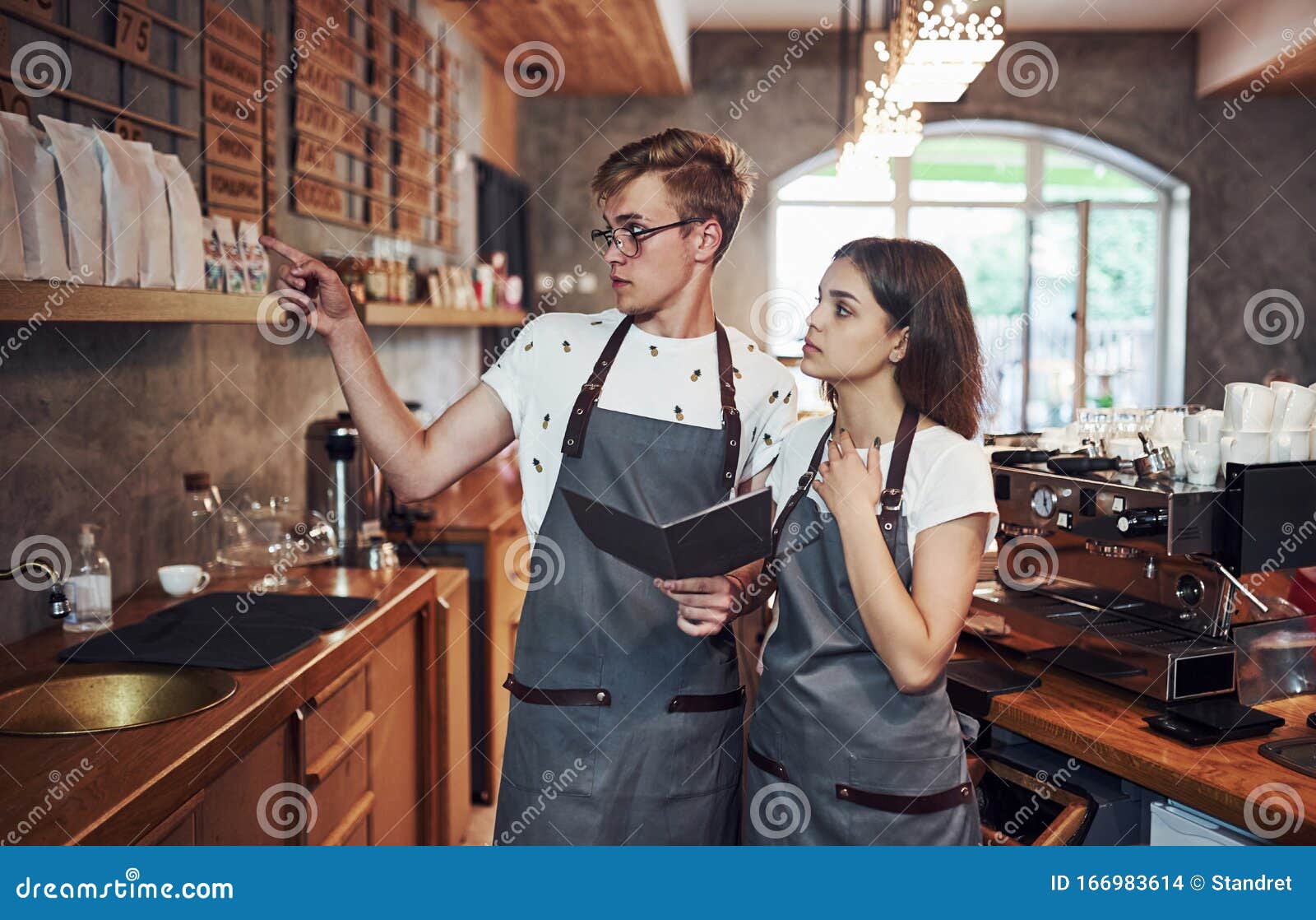 With Notepad. Talking with Each Other. Two Young Cafe Workers Indoors ...
