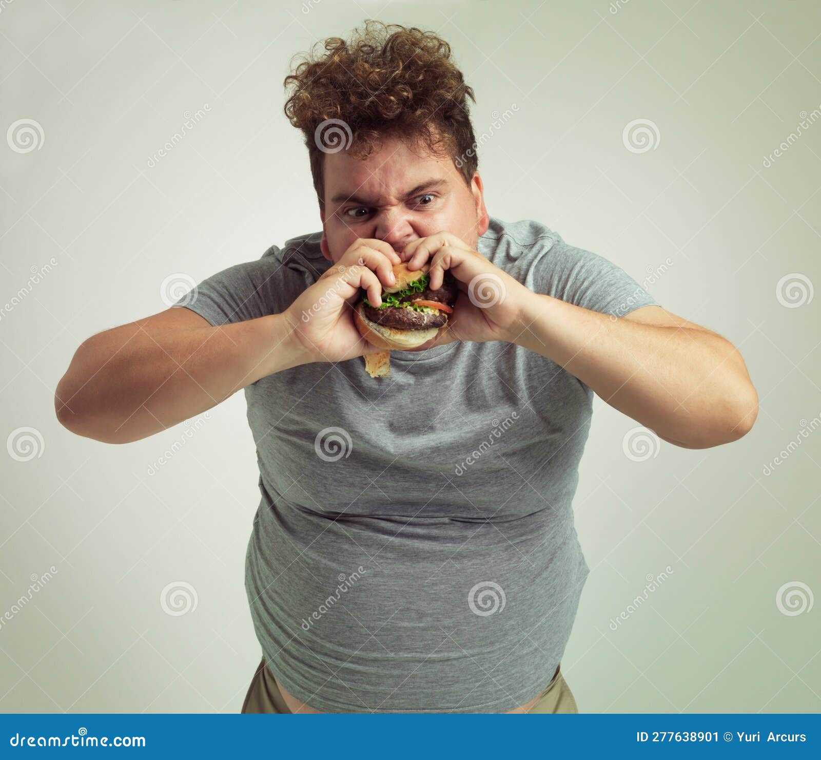 Nothing Beats a Good Burger. Studio Shot of an Overweight Man Biting ...