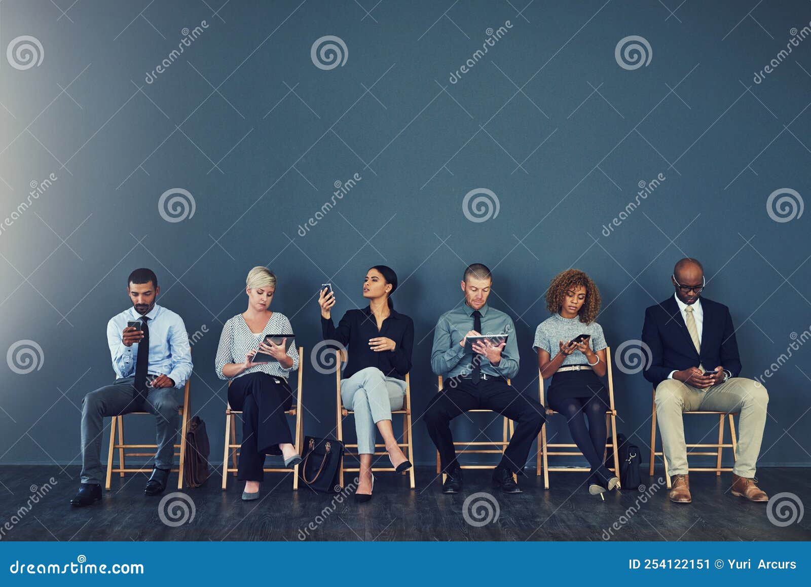Now Comes the Wait. Studio Shot of a Group of Businesspeople Using ...
