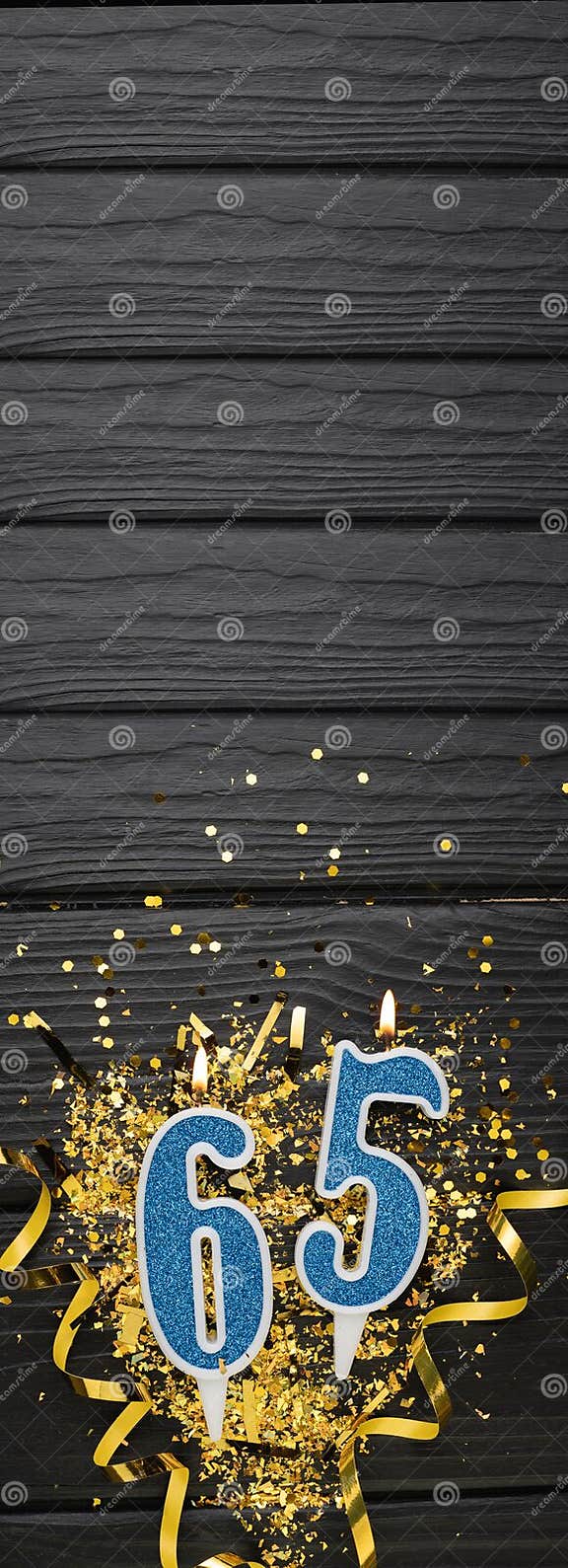 Number 65 Blue Celebration Candle And Gold Confetti On Dark Wooden