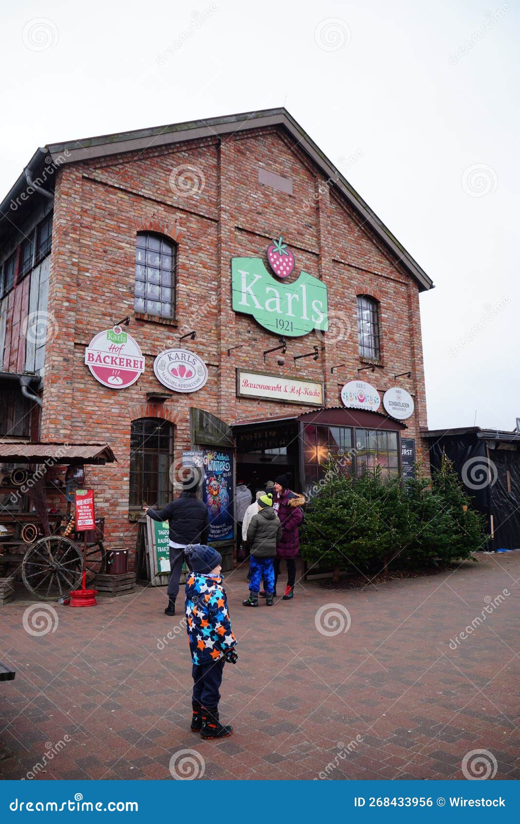 Number of People Standing in Front of a Red Brick Storefront in Germany ...