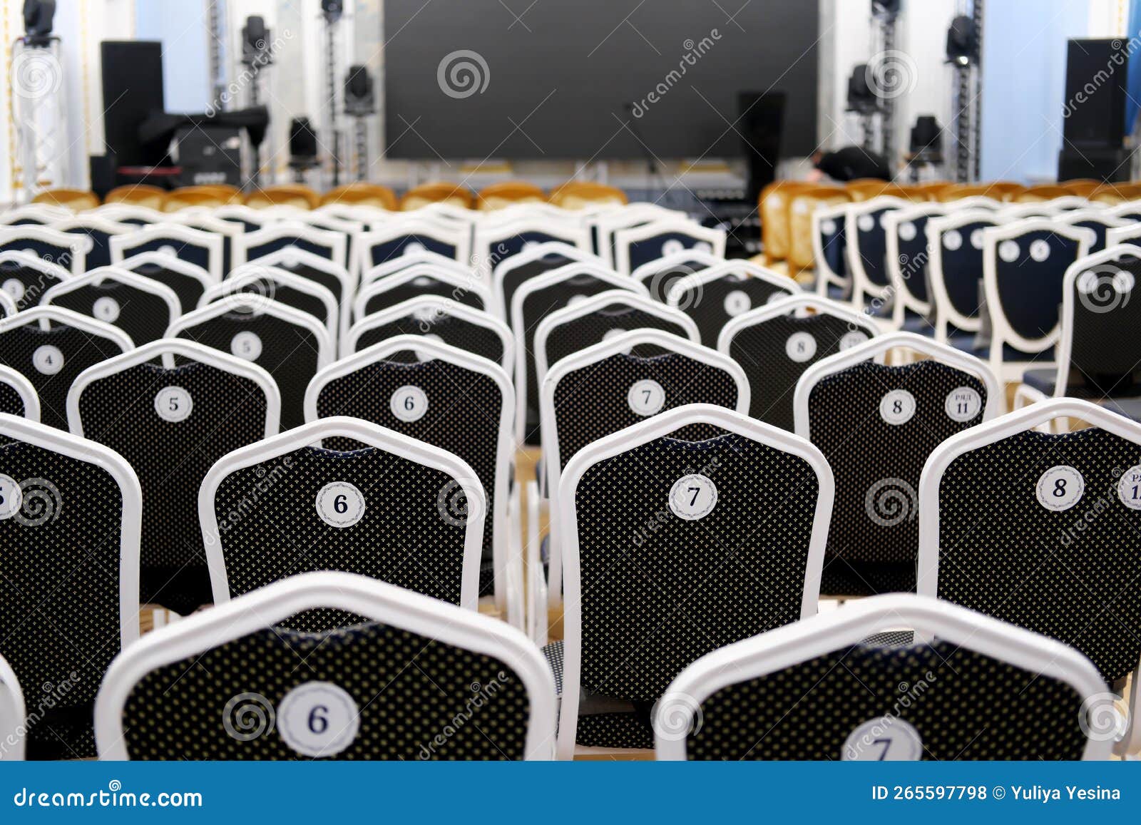 Numbered Chairs Stand in a Row Against the Backdrop of a Large Screen ...