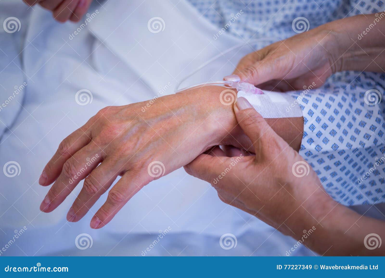 Nurse Attaching Intravenous Tube To Patient`s Hand In Hospital Bed ...