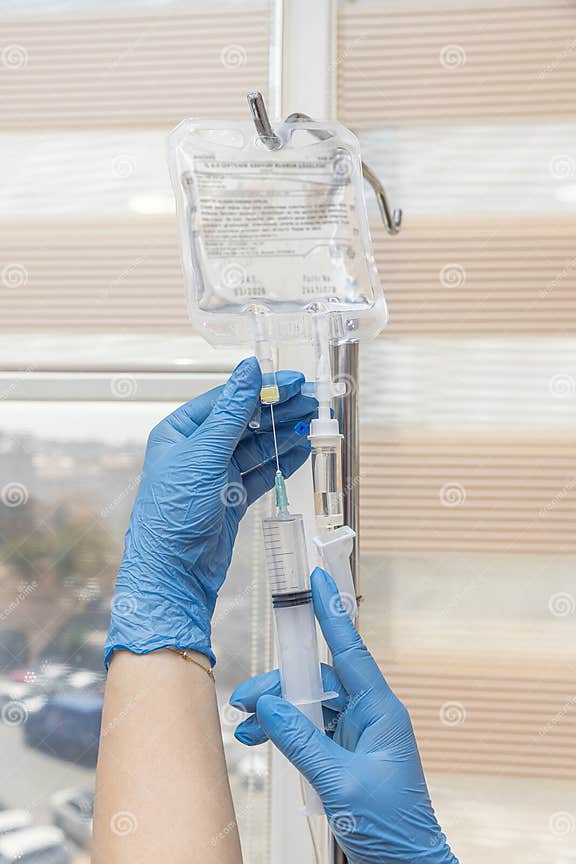 Nurse Connecting An Iv Drip Nurse Preparing And Regulating Infusion