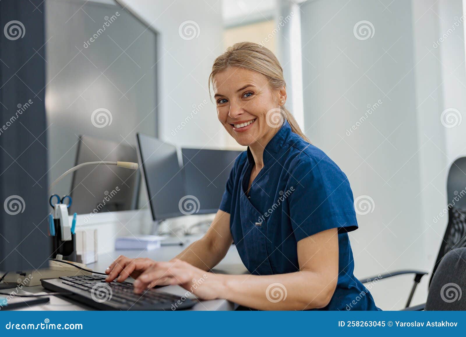 Nurse on Duty Working on Computer at the Reception Desk in Modern ...
