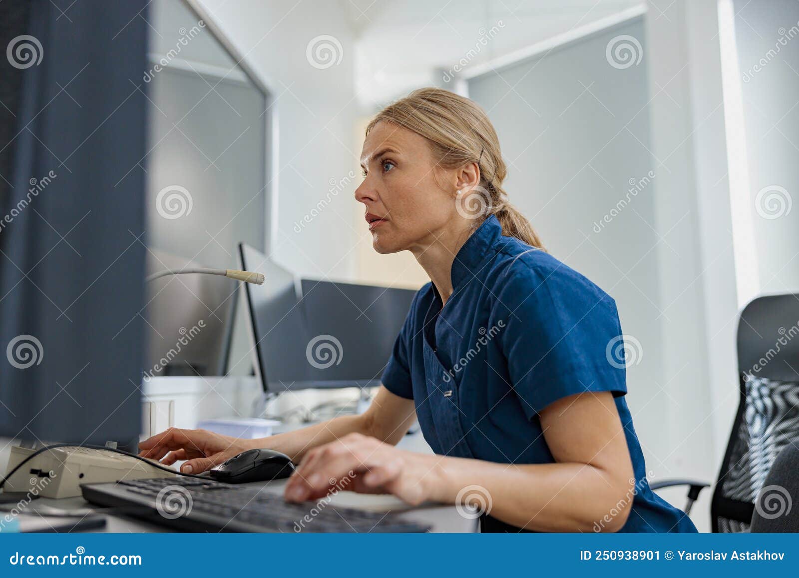Nurse on Duty Working on Computer at the Reception Desk in Modern ...