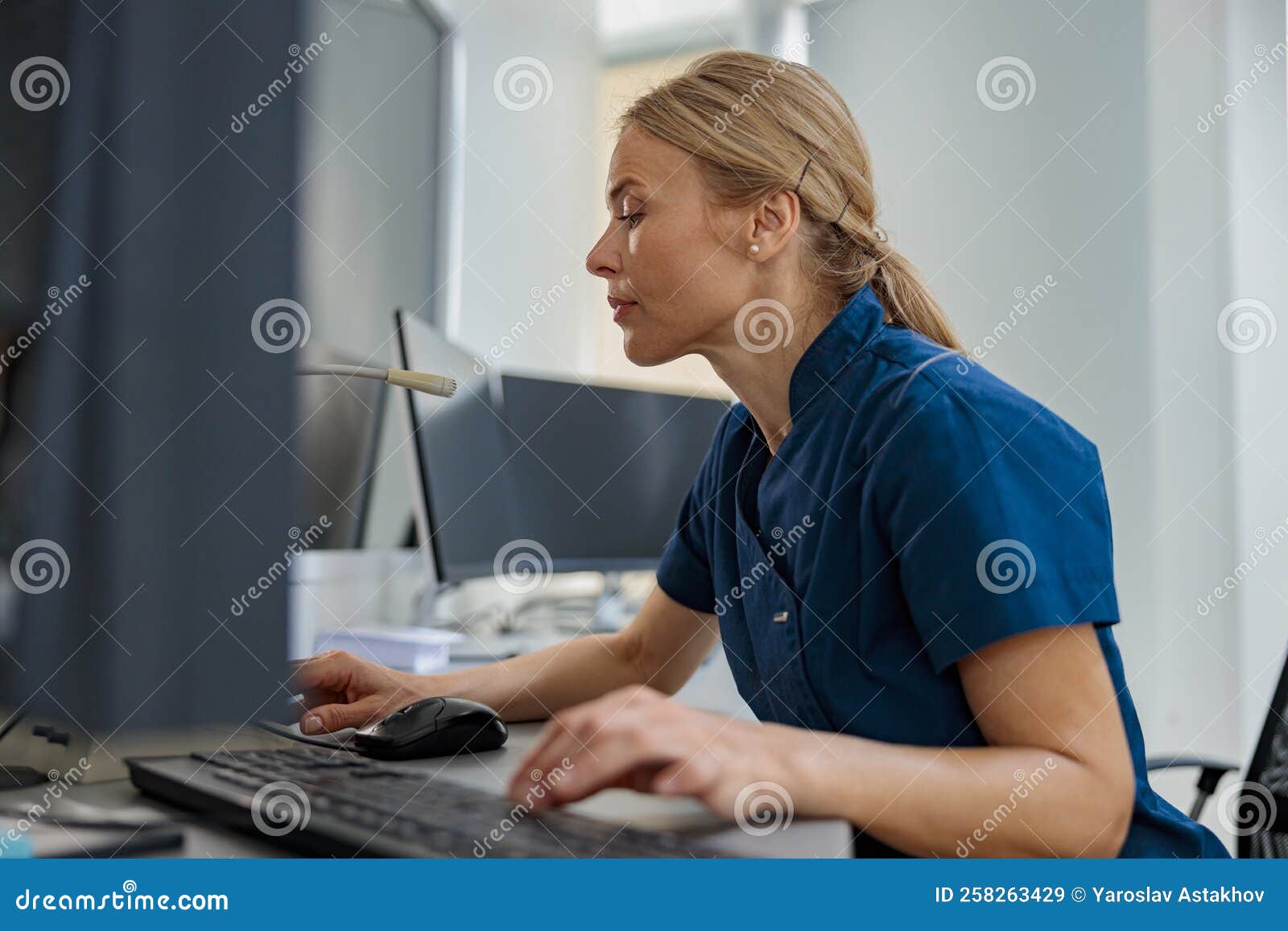 Nurse on Duty Working on Computer at the Reception Desk in Modern ...