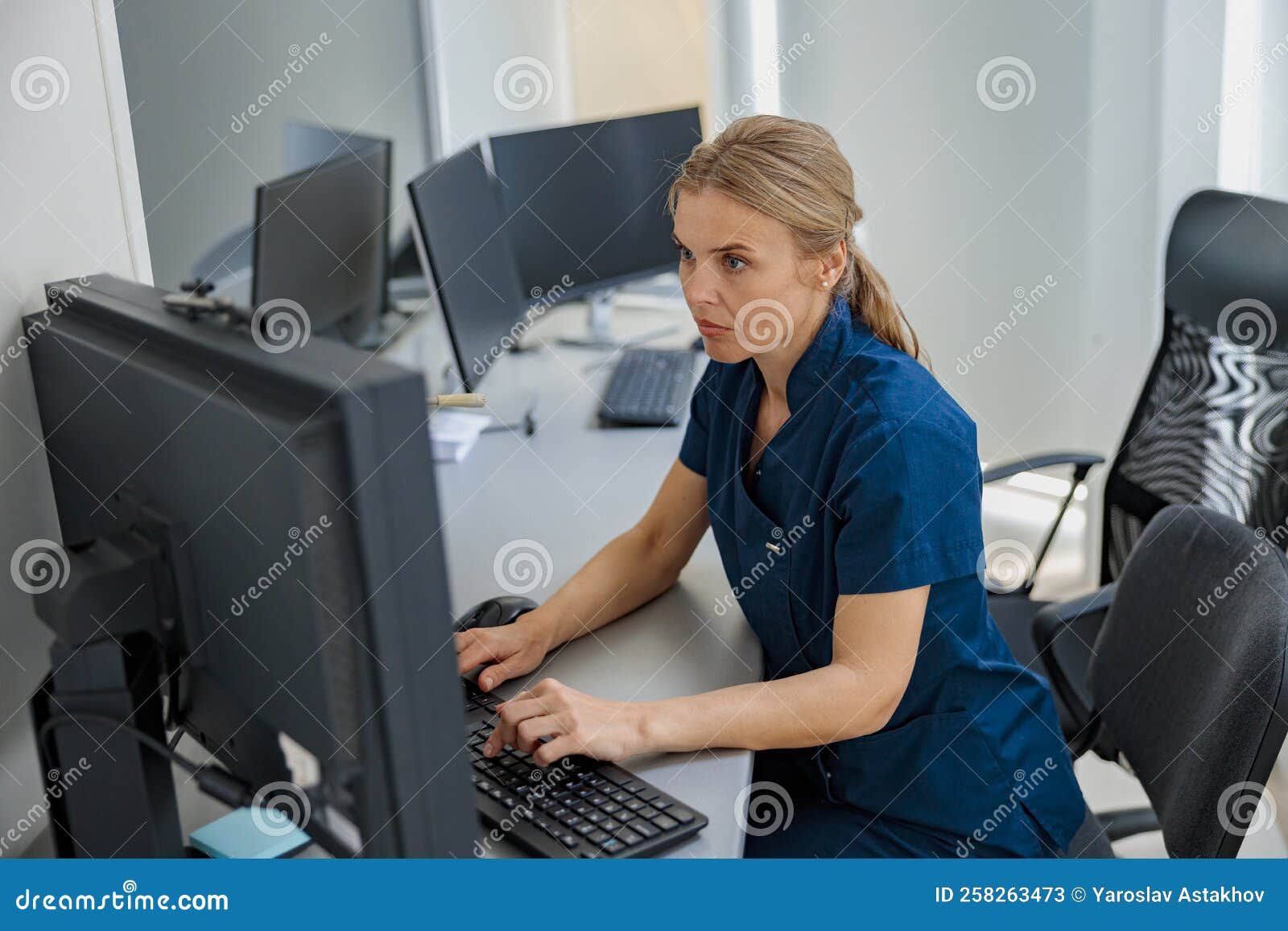 Nurse on Duty Working on Computer at the Reception Desk in Modern ...