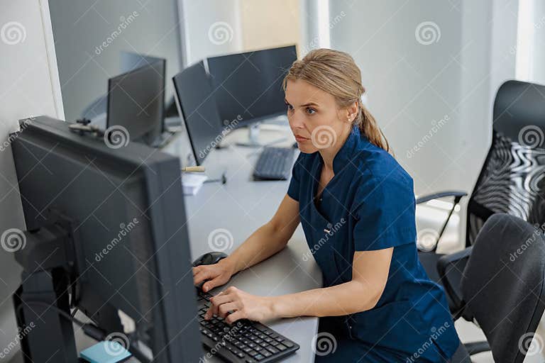 Nurse on Duty Working on Computer at the Reception Desk in Modern ...