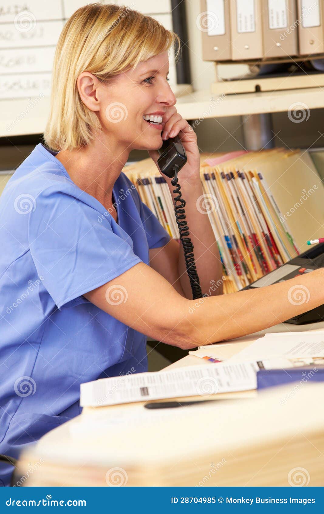 Nurse Making Phone Call at Nurses Station Stock Image - Image of ...