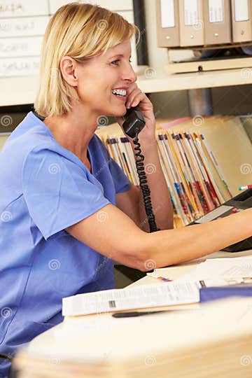 Nurse Making Phone Call at Nurses Station Stock Image - Image of ...