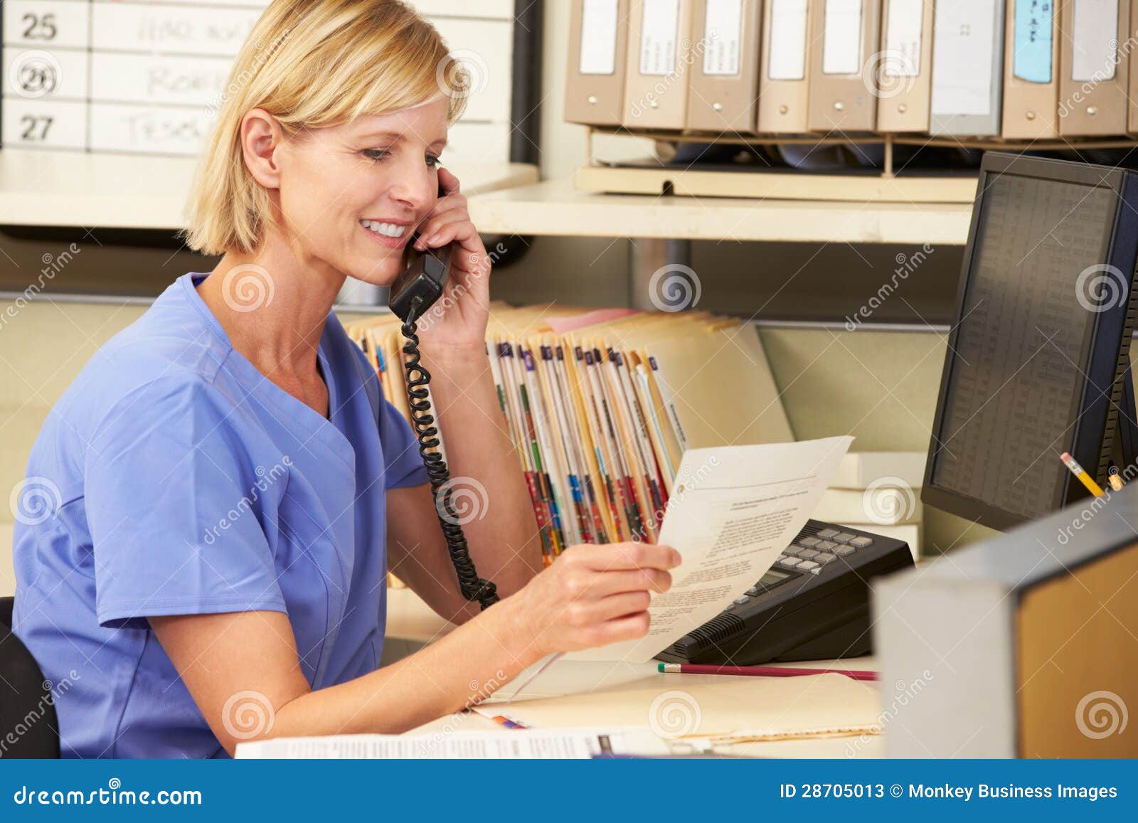 Nurse Making Phone Call at Nurses Station Stock Image - Image of people ...