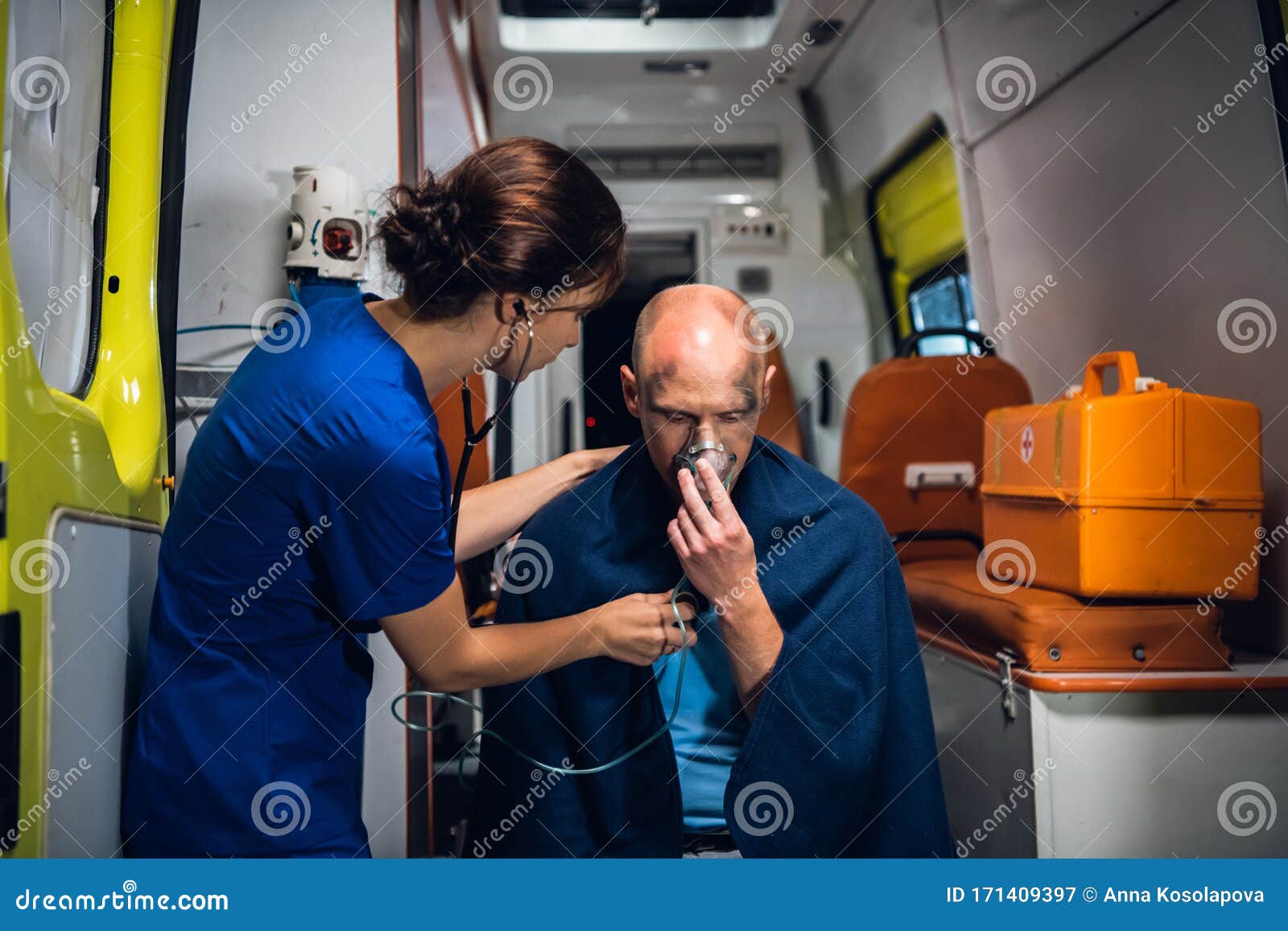 Nurse In Medical Uniform Puts Her Hand On Man Who Sits In Oxygen Mask