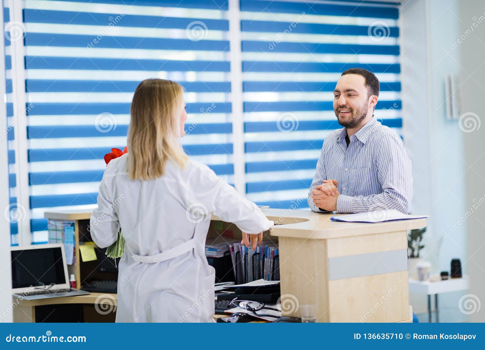 Nurse and Patient Conversing at Reception Desk in Hospital Stock Photo ...
