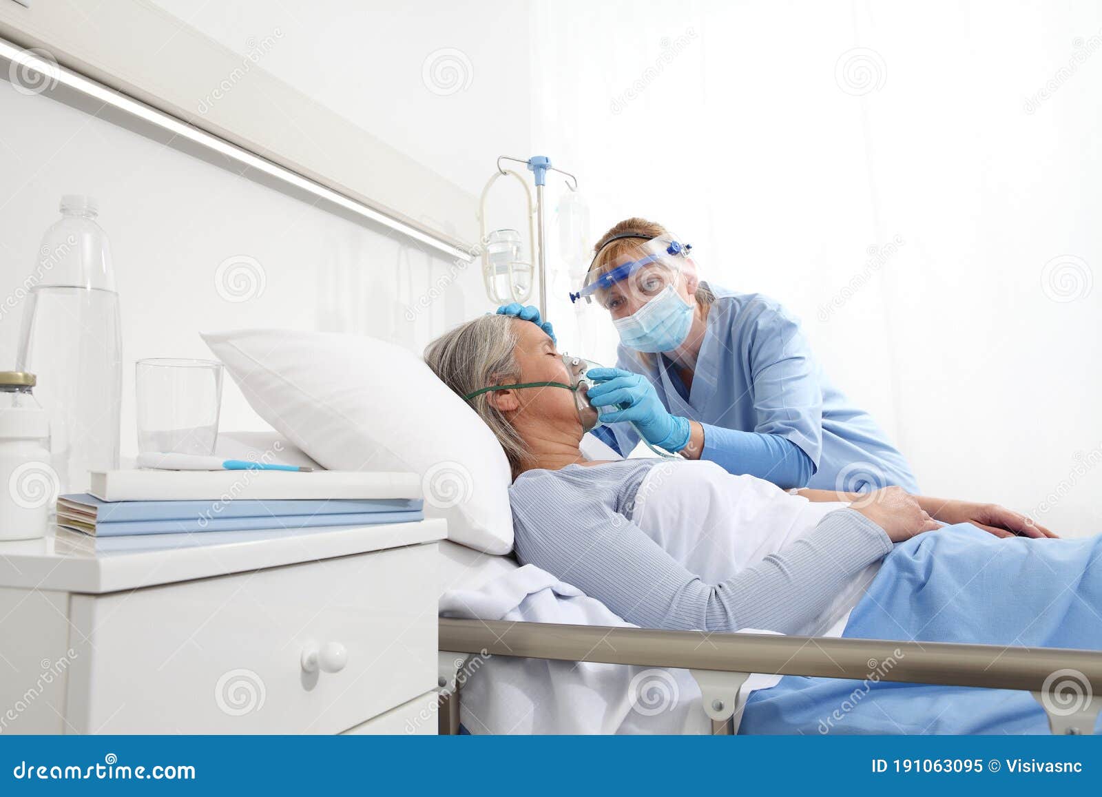 Nurse Puts Oxygen Mask On Elderly Woman Patient Lying In The Hospital