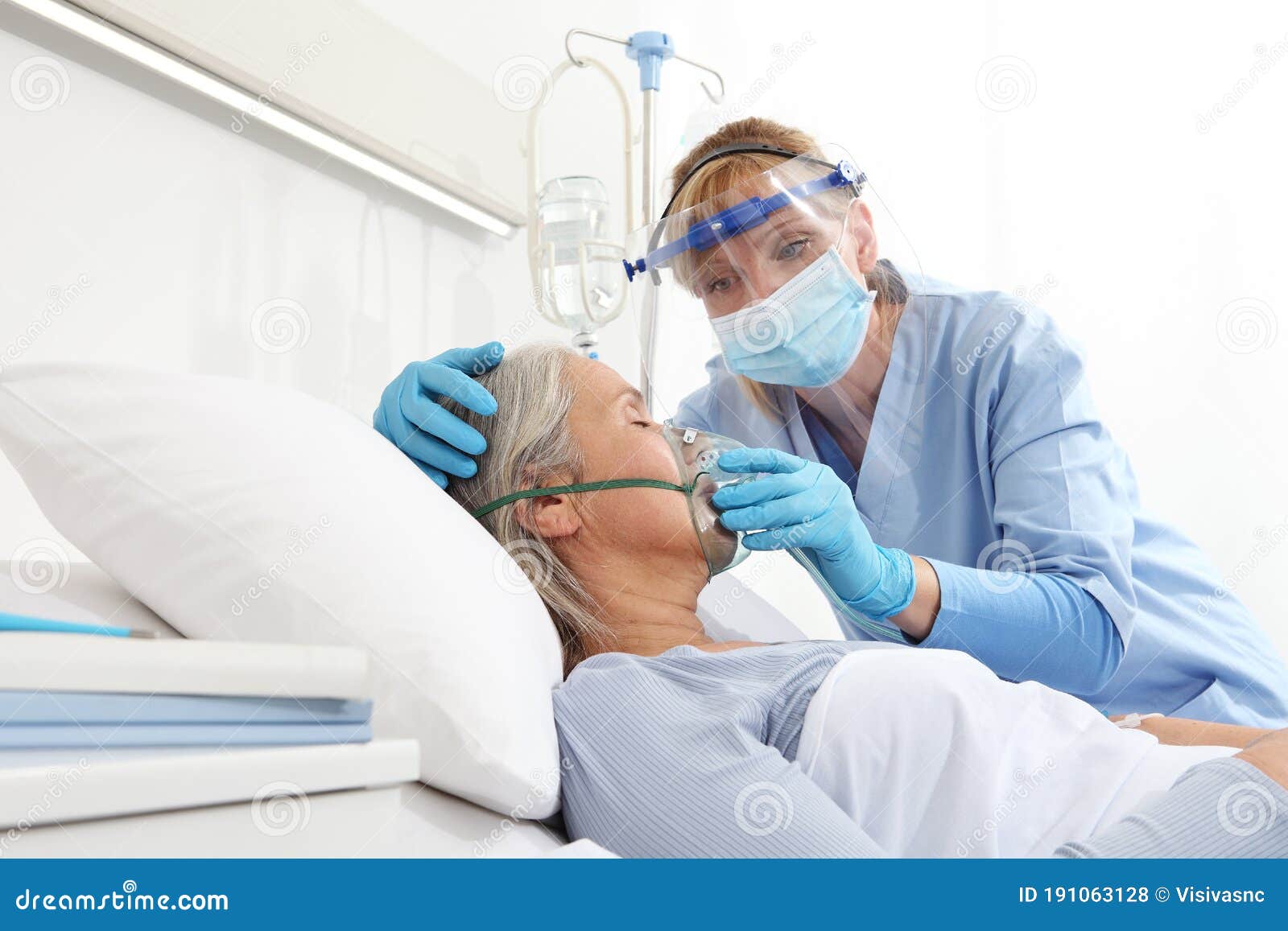Nurse Puts Oxygen Mask On Elderly Woman Patient Lying In The Hospital