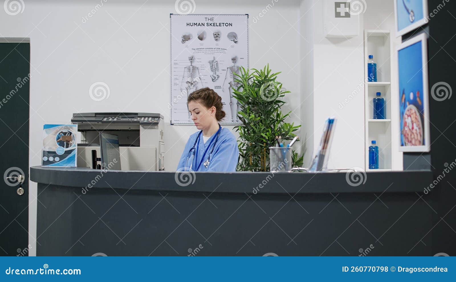 Nurse Using Computer To Make Checkup Appointments at Reception Desk ...