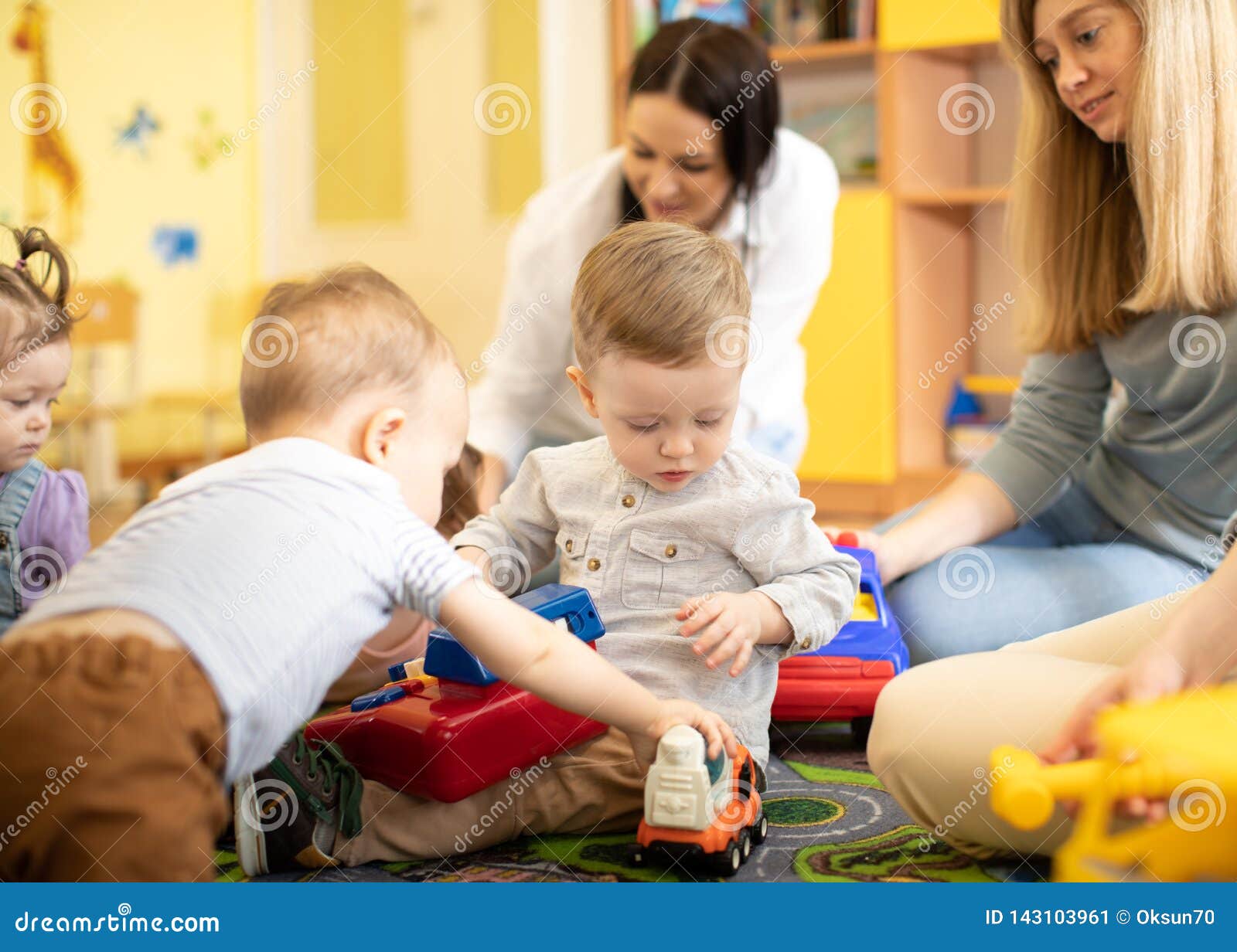 Nursery Babies Playing Together with Moms in a Play Room Stock Image ...