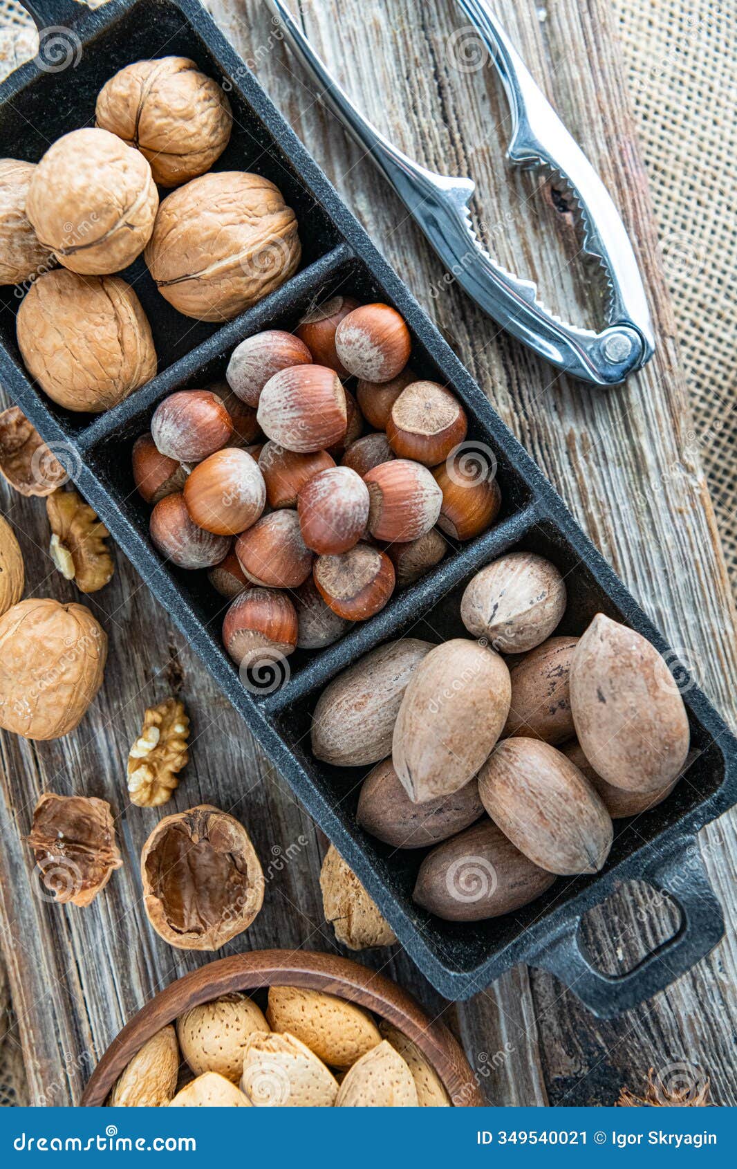 Nutcracker Cracking Nuts and Assorted Nuts in a Plate on a Dark Wooden ...