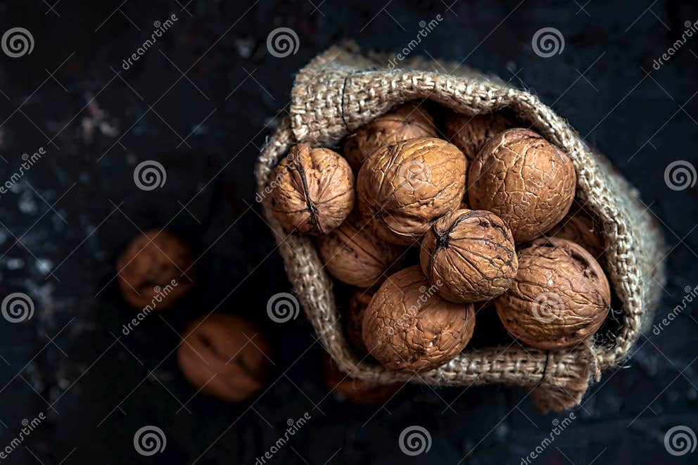 Nuts. Walnut Kernels and Whole Walnuts on Dark Stone Table. Black ...