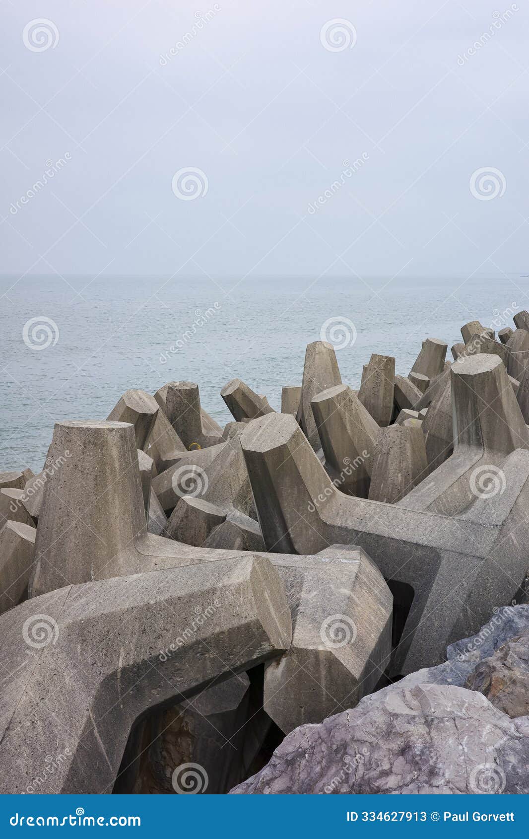 Ocean Defense Concrete Wave Breakers Along a Cloudy Coastline with Calm ...