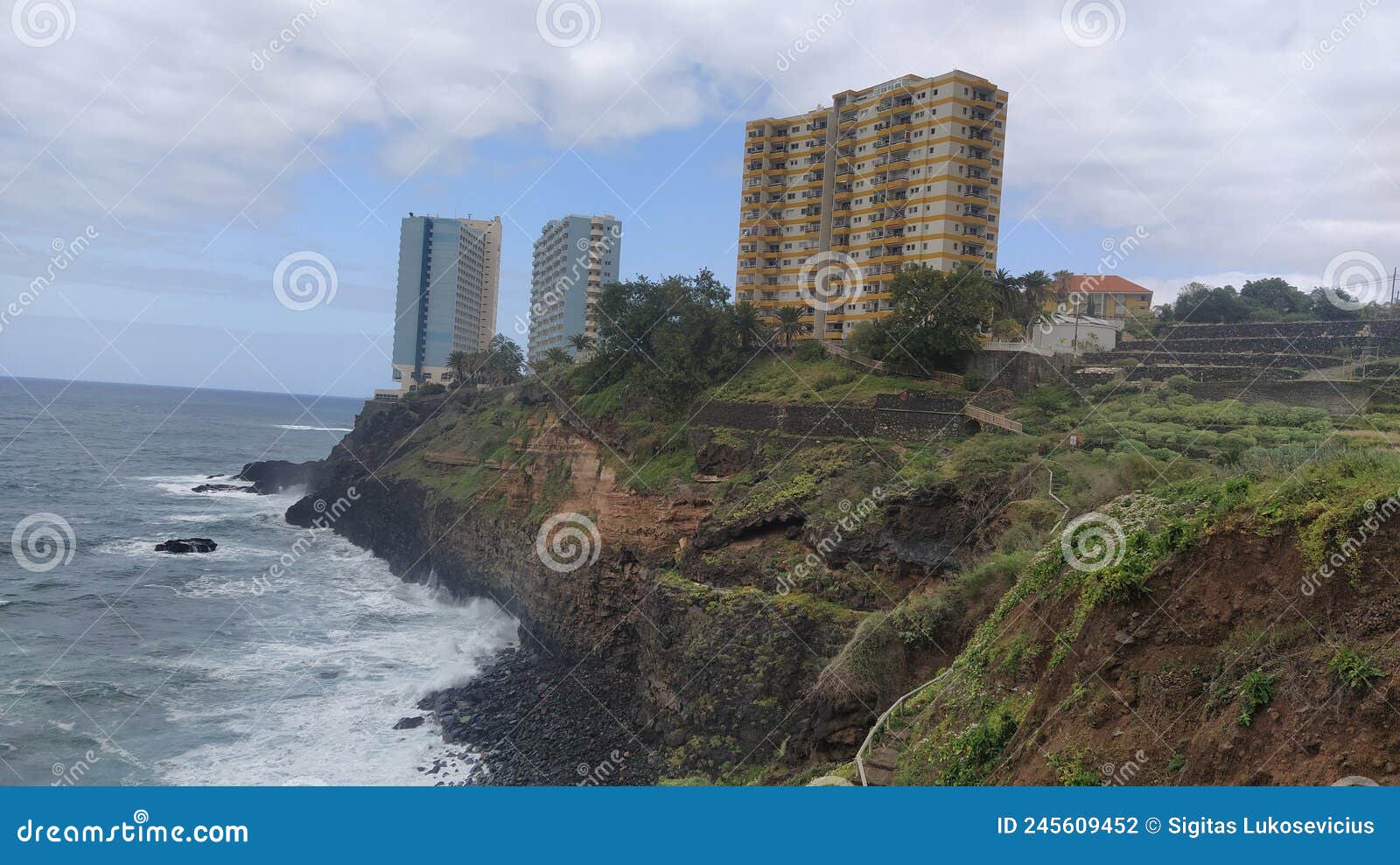 Ocean shore with buildings stock photo. Image of rock - 245609452