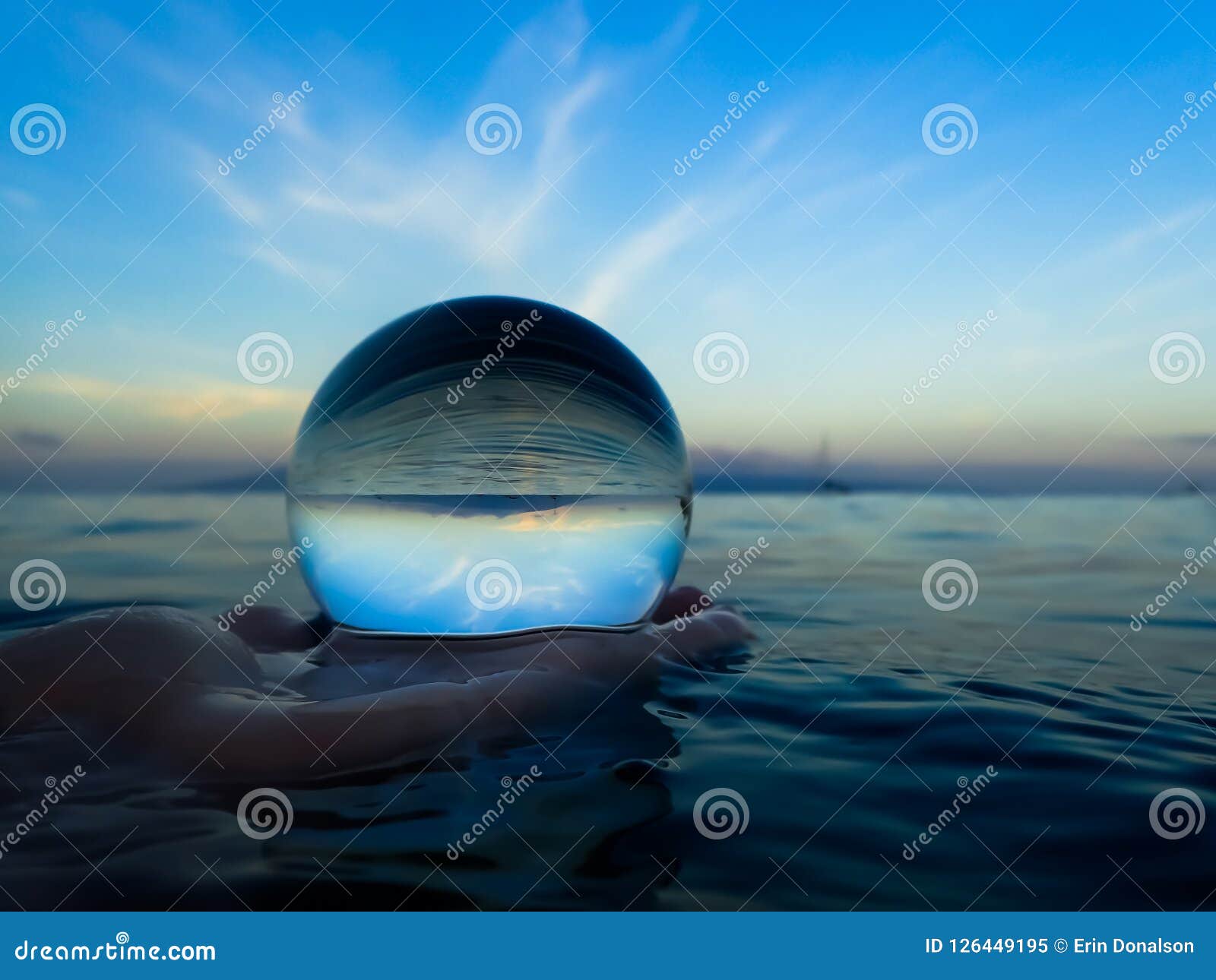 Ocean Surface Reflection in Glass Ball Held in Hand in Water Stock ...