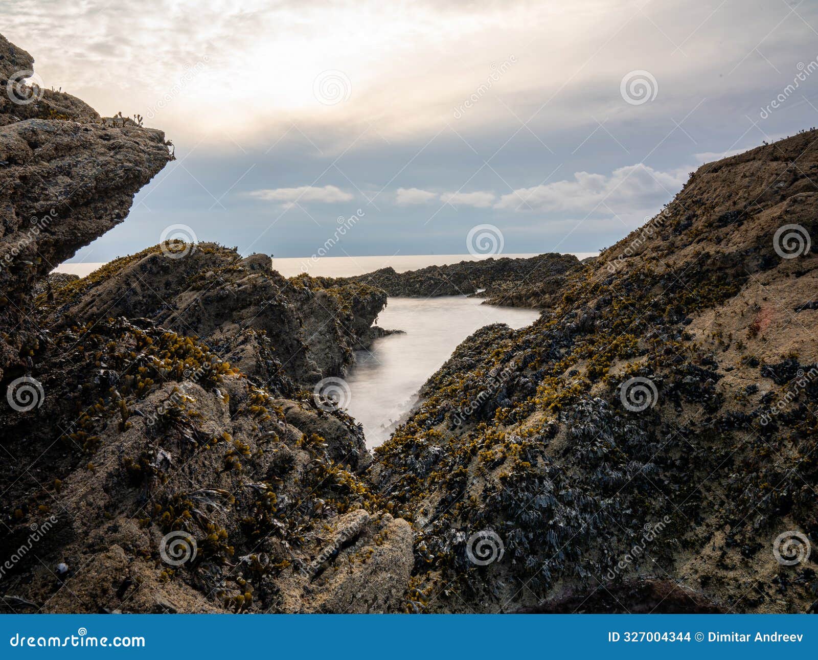 Ocean Water Rushing between Rocks at Sunset on the Beach Stock Photo ...