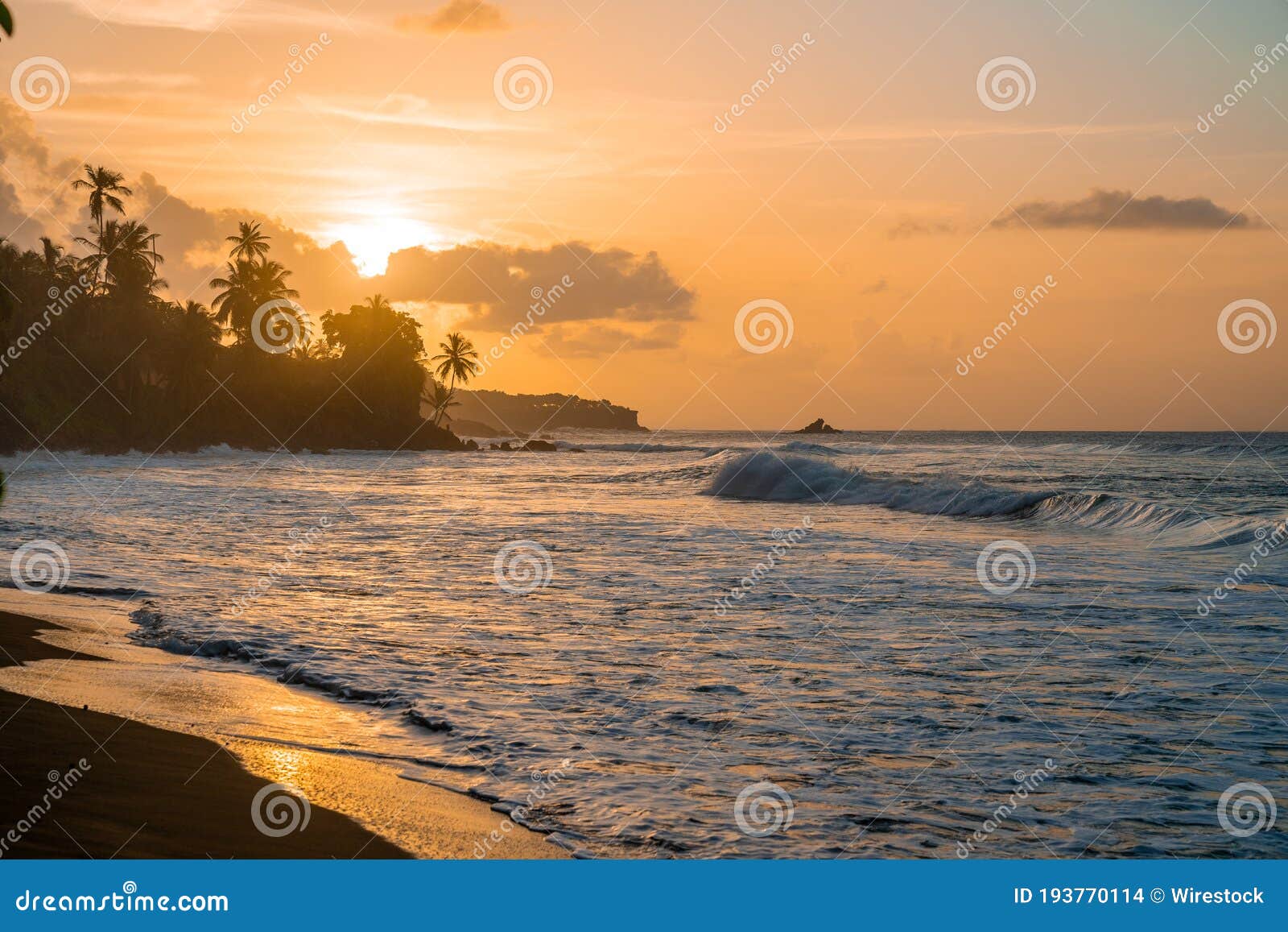 Ocean Waves Hitting The Sandy Beach And Gleaming Under The Sunset Stock ...