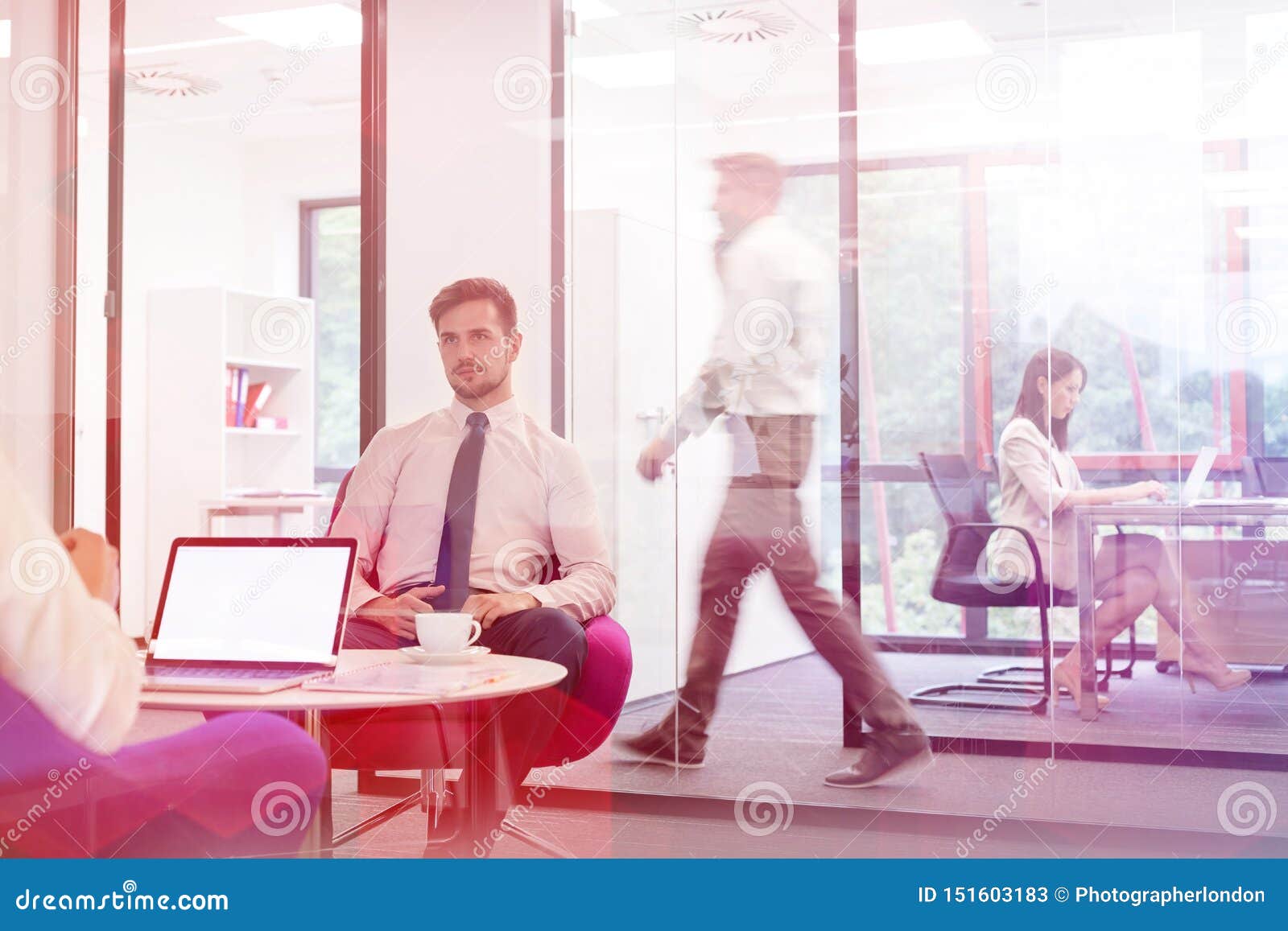 Businessmen Discussing in Boardroom while Colleagues Working in ...