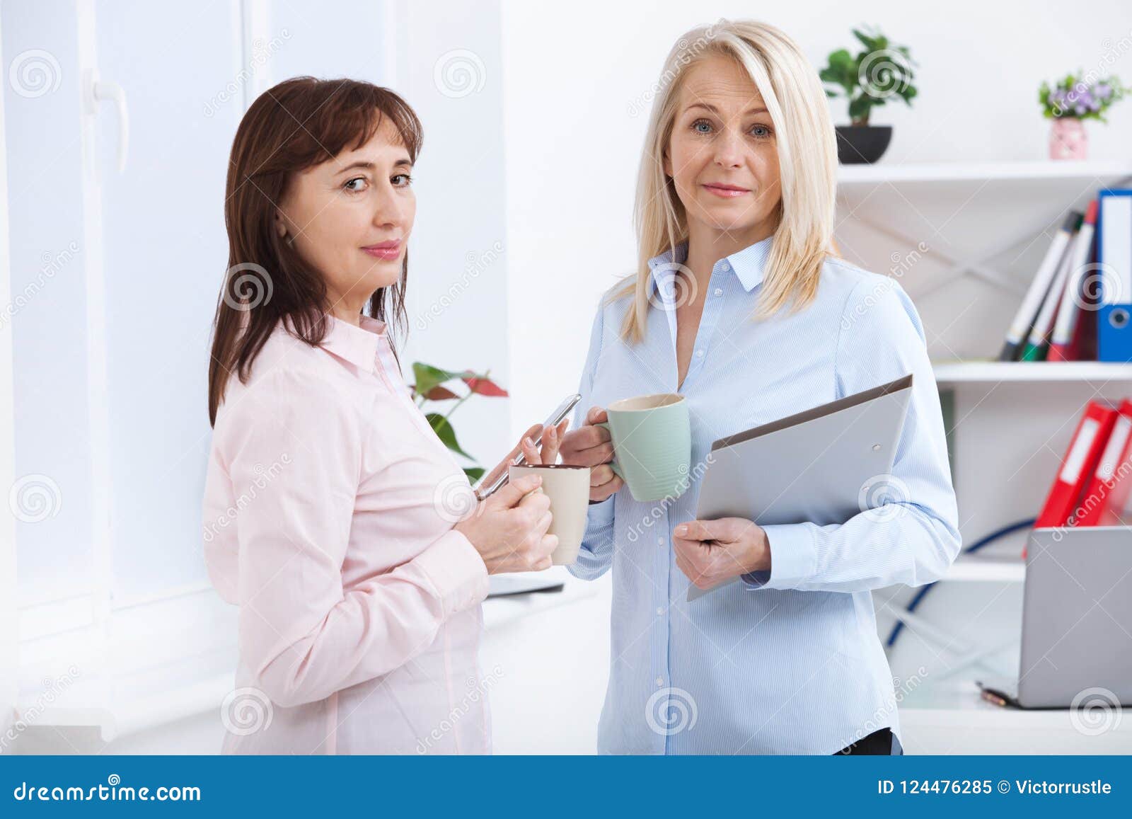 Office Coffee Break. Two Female Colleagues with Cups of Coffee Talking ...