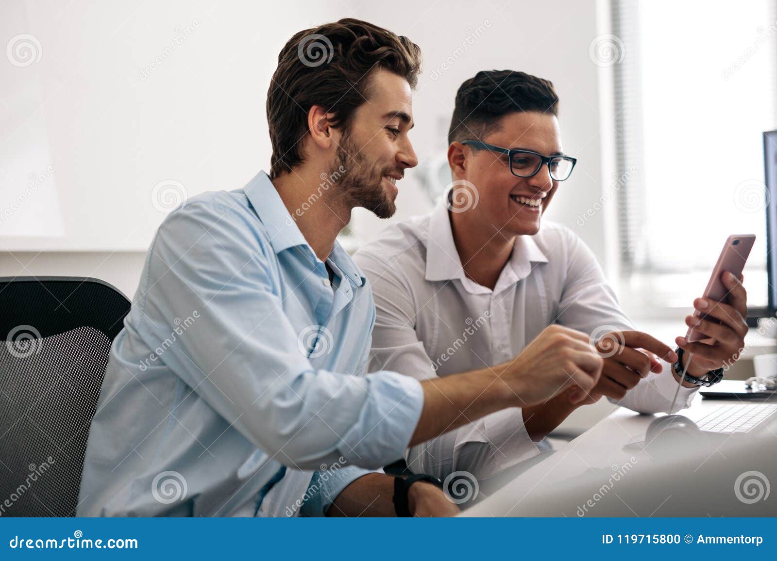 Office Colleagues Looking at Mobile Phone in Office Stock Photo - Image ...