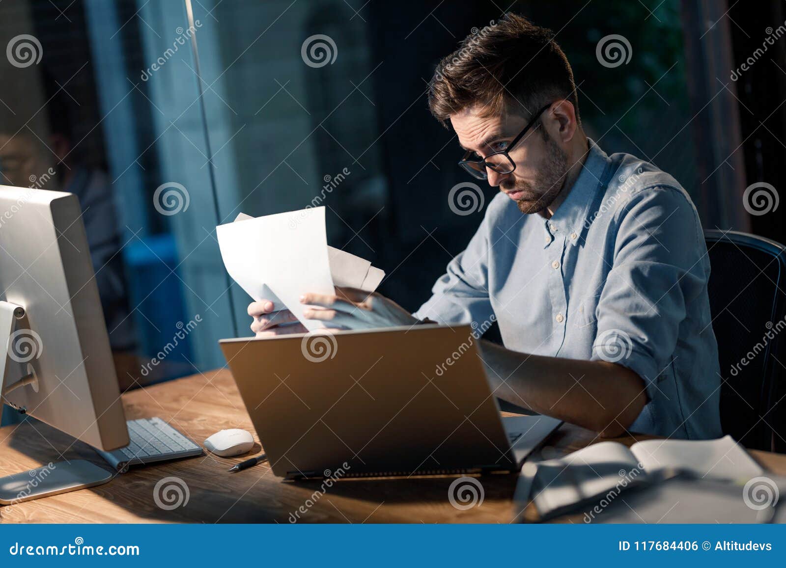 Man with papers at laptop stock photo. Image of entrepreneur - 117684406