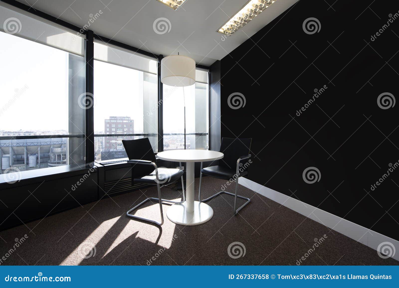 Office with a Small White Round Table Next To a Large Window with a ...