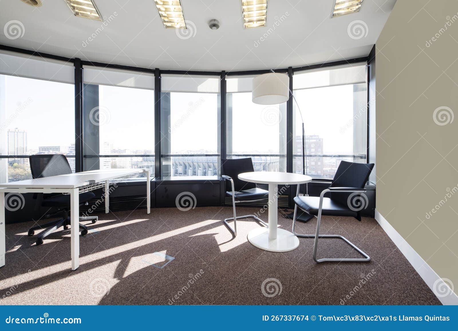 Office with a Small White Round Table Next To a Large Window with Views ...