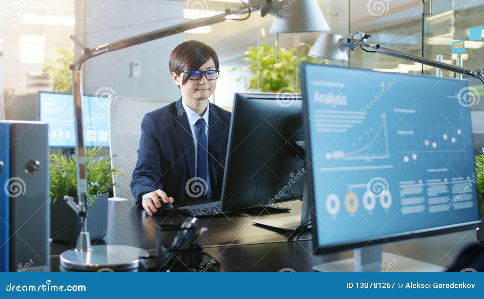 In the Office Smiling East Asian Businessman Works on a Desktop Stock ... In the Office Smiling East Asian Businessman Works on a Desktop Stock ...