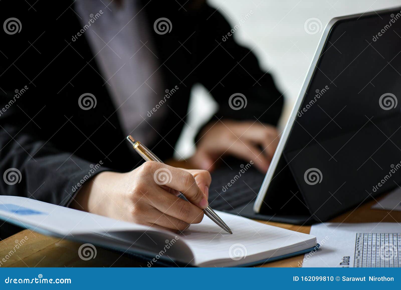 Office Staff Use Laptop Computer and Note in Notebook on Desk in Office ...