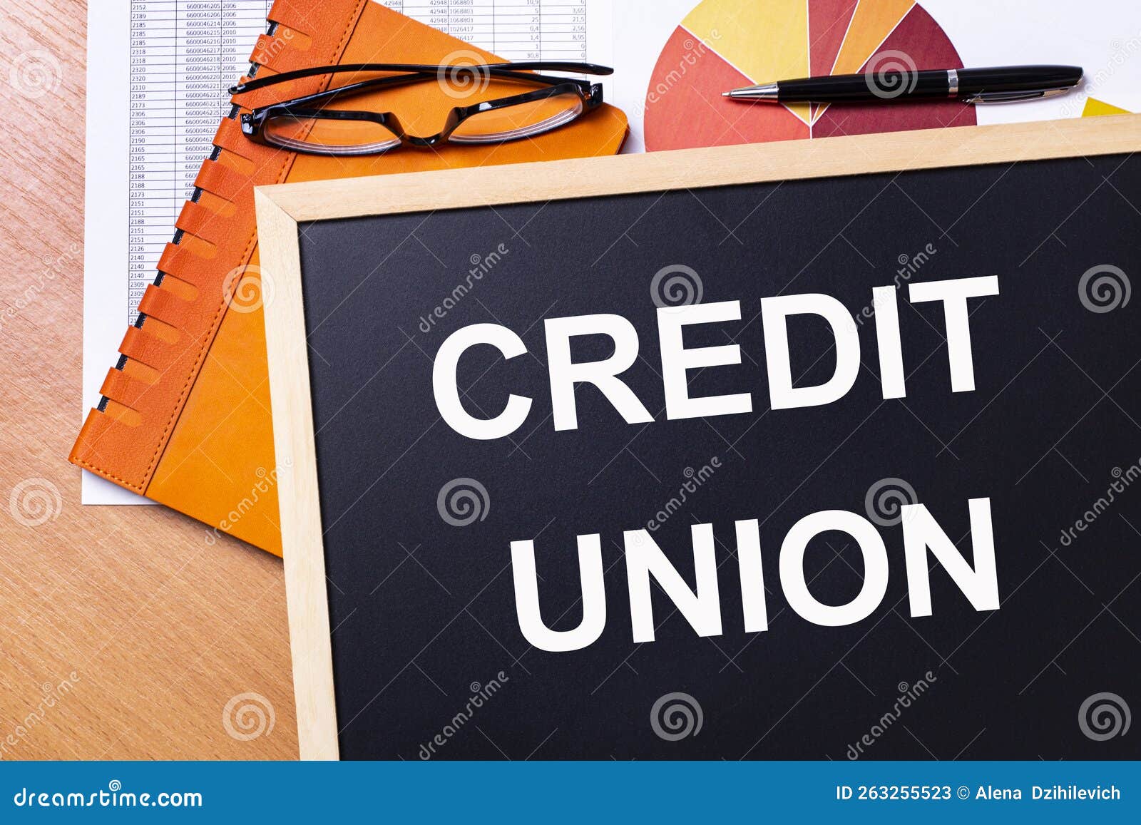 On the Office Table is an Orange Notepad, Black Glasses, a Pen and a ...