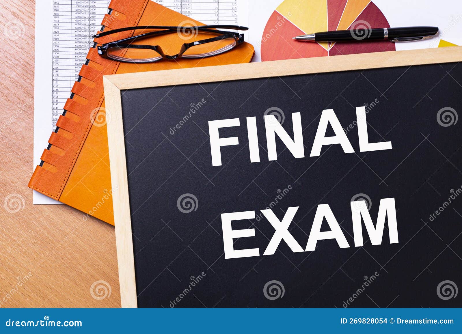 On the Office Table is an Orange Notepad, Black Glasses, a Pen and a ...