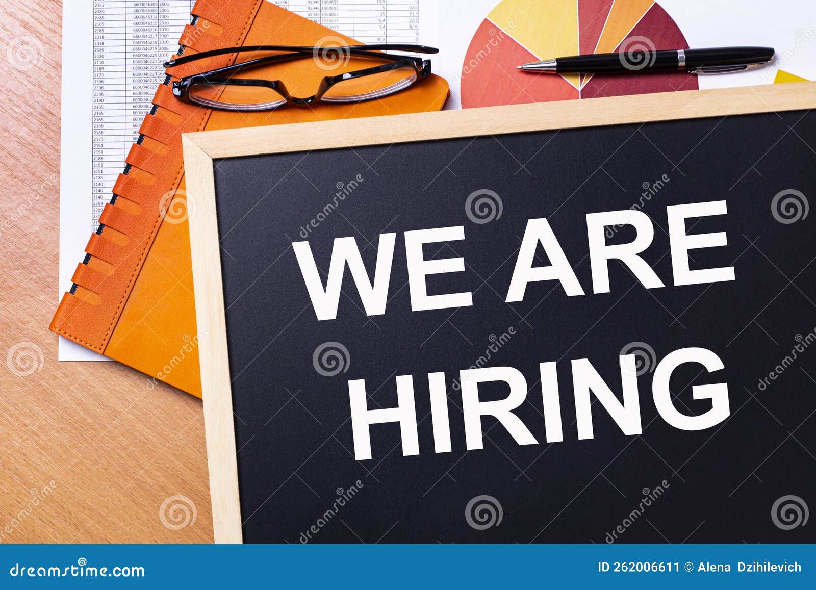 On the Office Table is an Orange Notepad, Black Glasses, a Pen and a ...