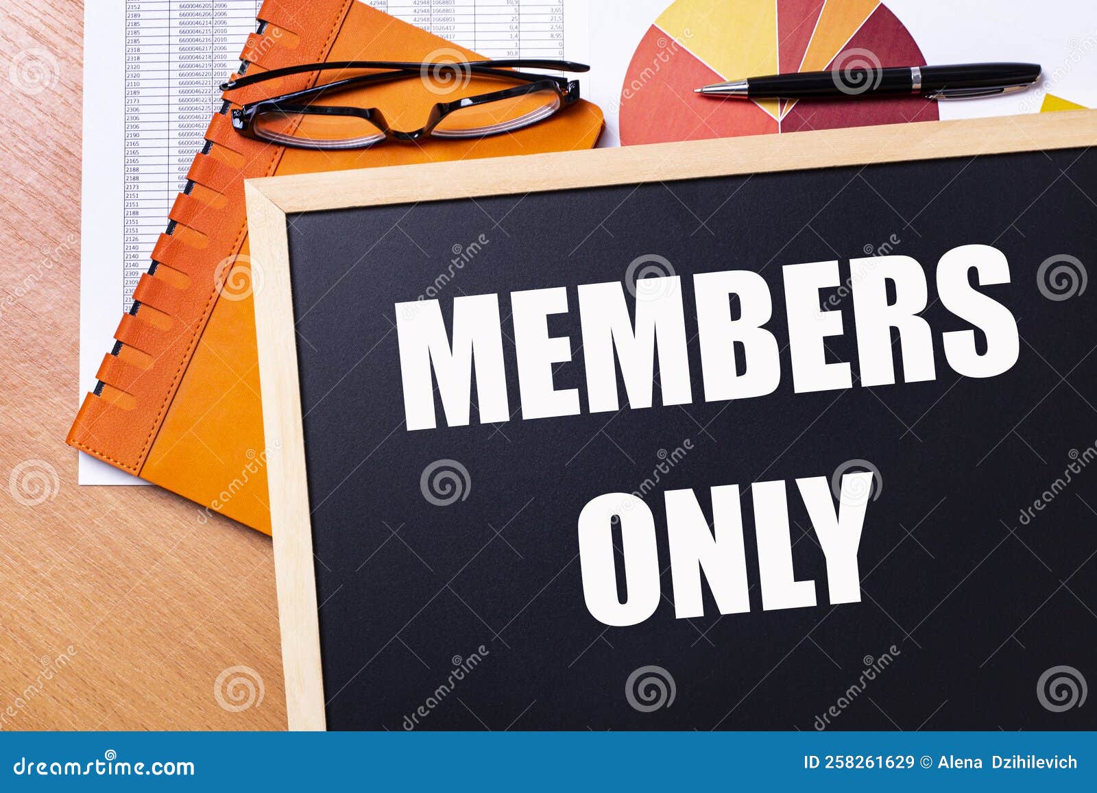 On the Office Table is an Orange Notepad, Black Glasses, a Pen and a ...