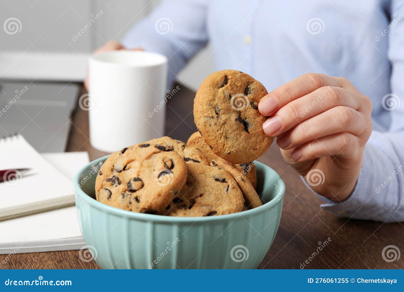 Office Worker with Cup of Drink Taking Chocolate Chip Cookie from Bowl ...