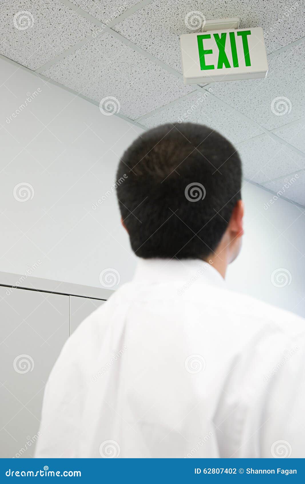Office Worker Looking at Exit Sign Stock Photo - Image of indoors ...