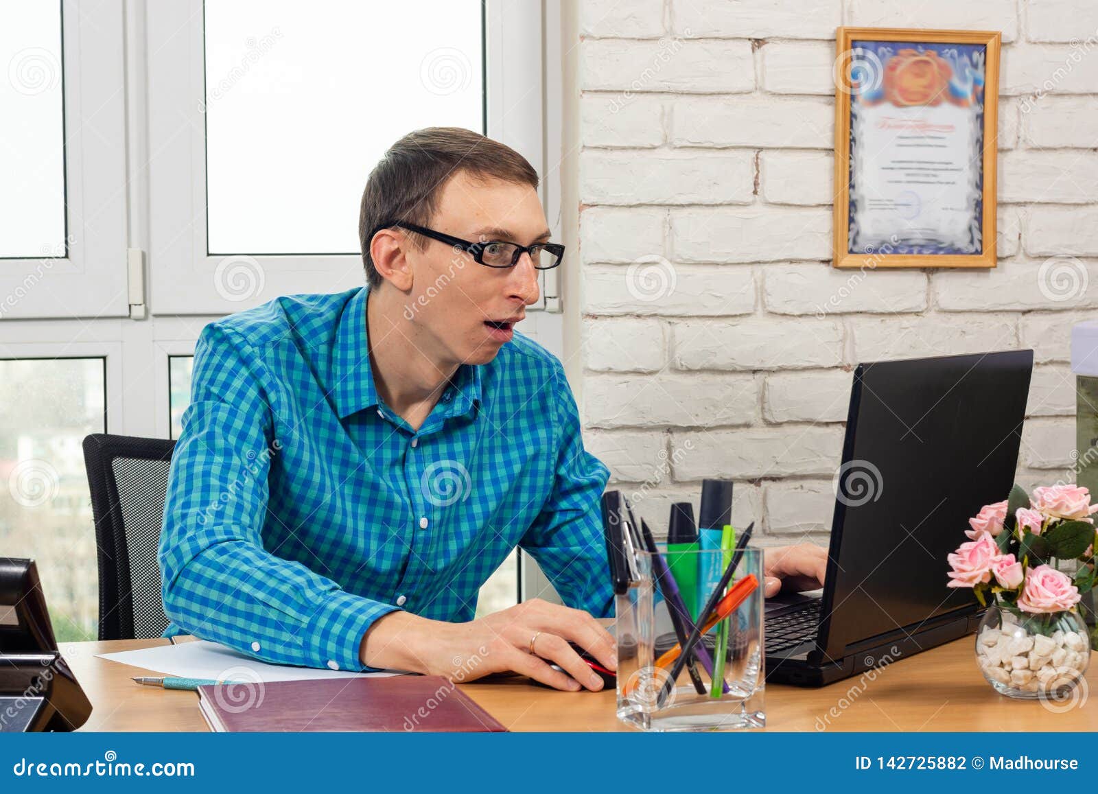 An Office Worker Looks at the Laptop Screen in Surprise Stock Photo ...