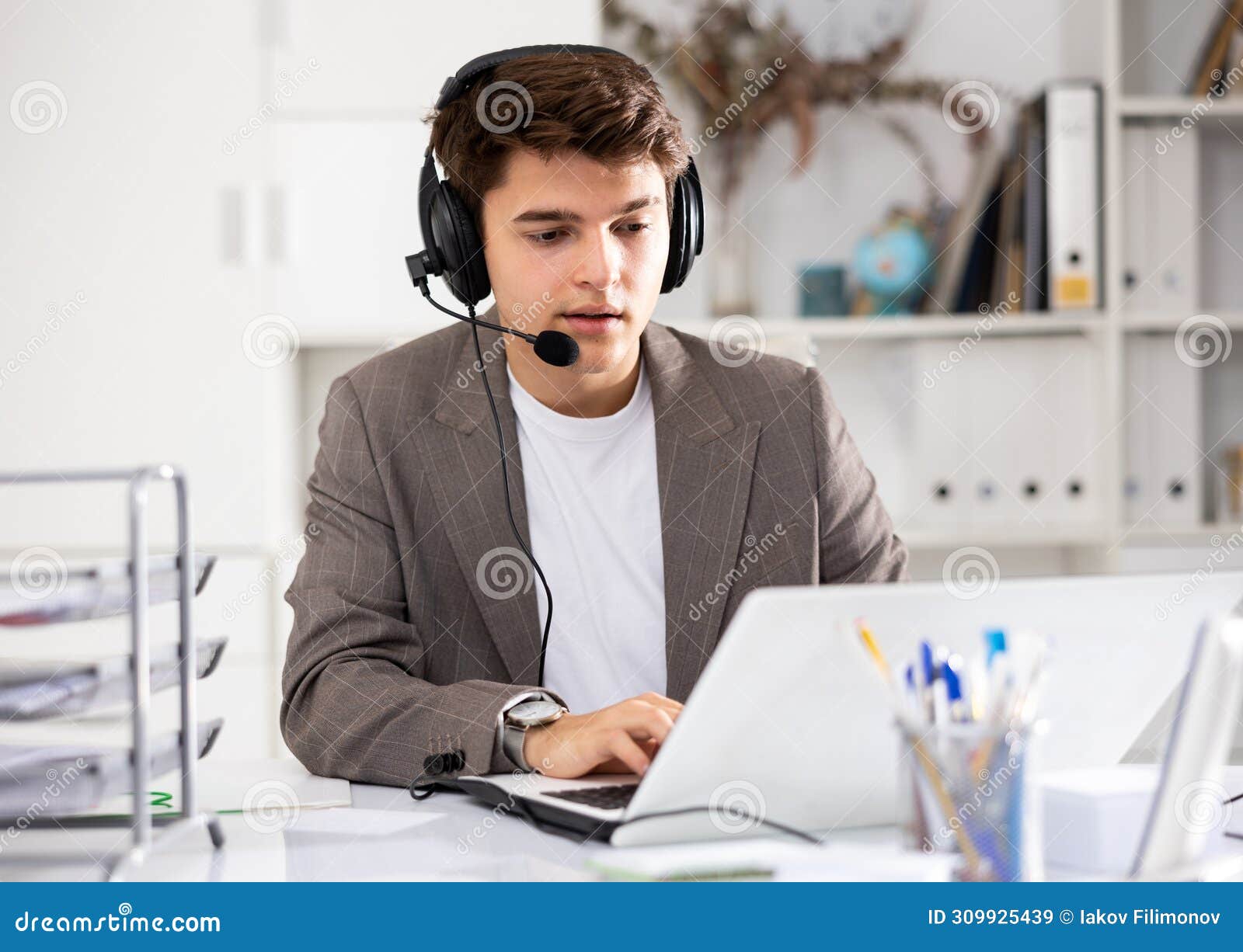Office Worker Man is Working at Computer and Talking by Headset with ...