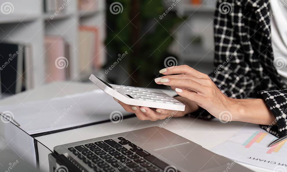 Office Worker Handling Paperwork and Using Calculator at Desk in Modern ...
