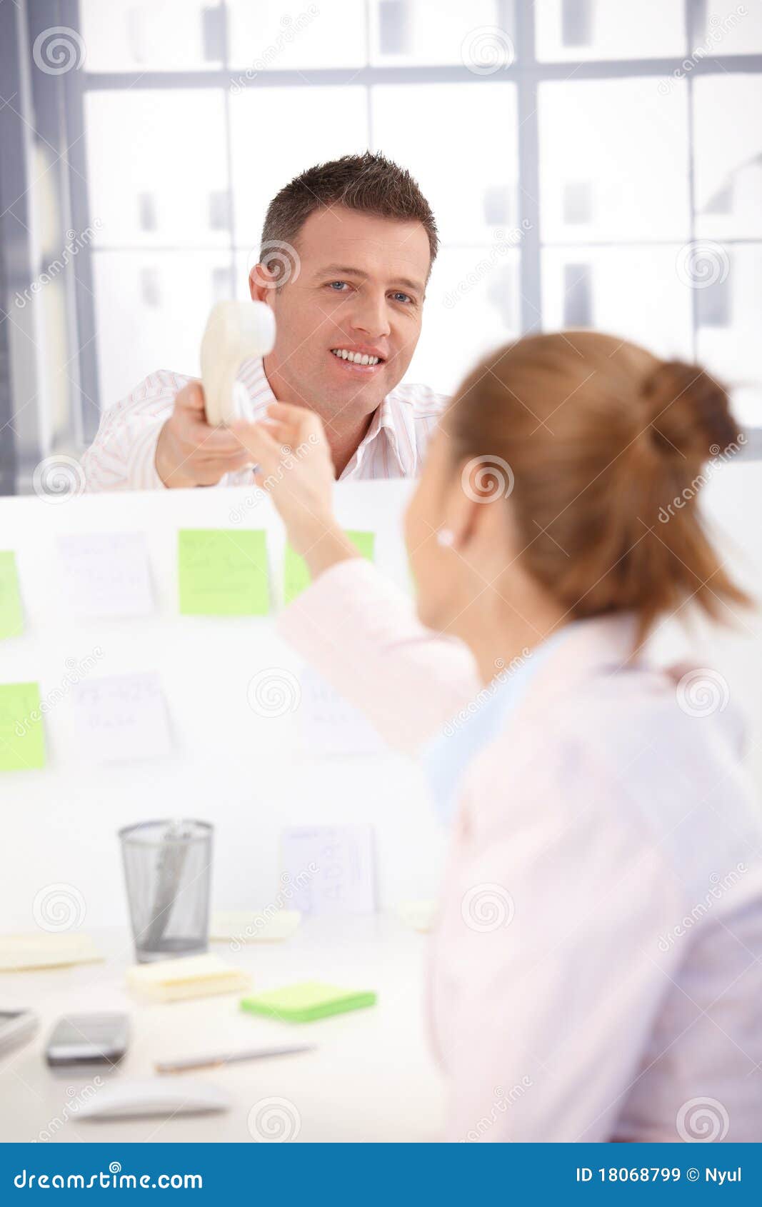 Office Worker Passing Phone To Colleague Stock Image - Image of middle ...